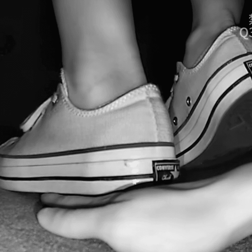 Girl in cinema wearing flat shoes + low-top Converse shoes candid trample hand